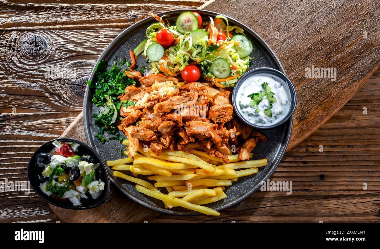 Kebab served with french fries, vegetable salad and tzatziki Stock ...