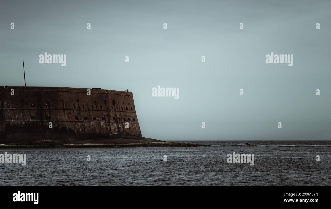 A low-key telephoto shot of a historic fortress Forte da Laje against a ...