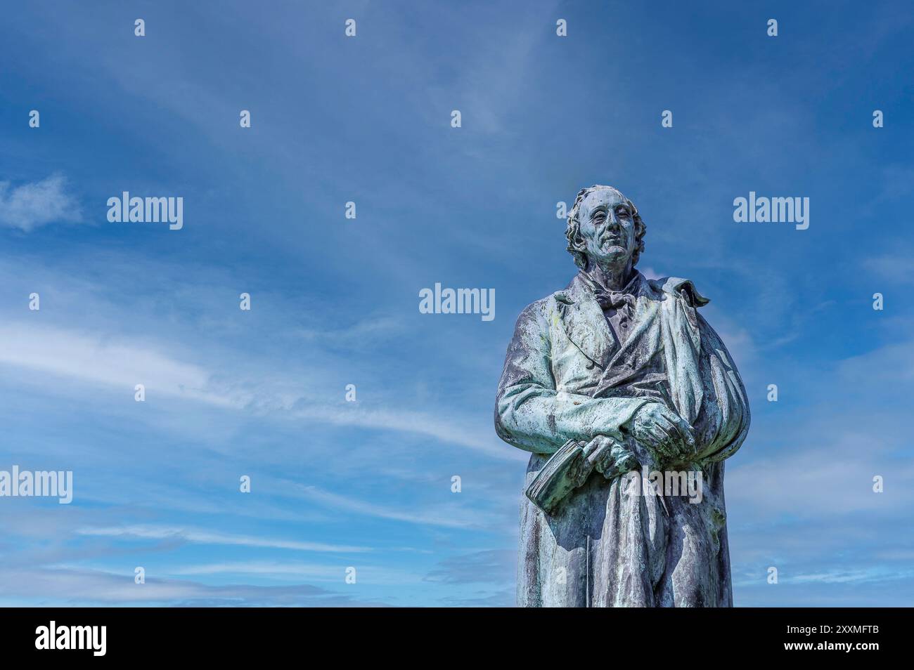 statue of Hans Christian Andersen holding a book and a pen in his hands ...