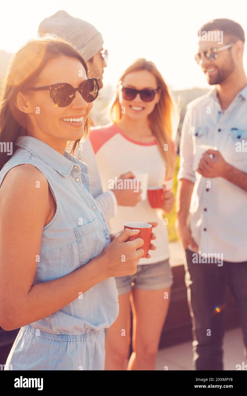 Coffee break with friends. Beautiful young woman holding coffee cup and ...