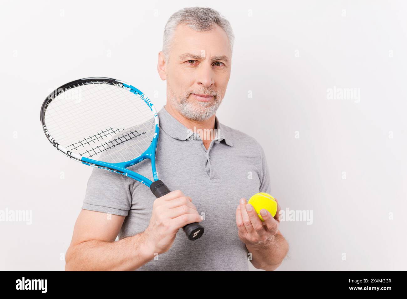 Ready to play. Confident grey hair senior man holding tennis racket and ...
