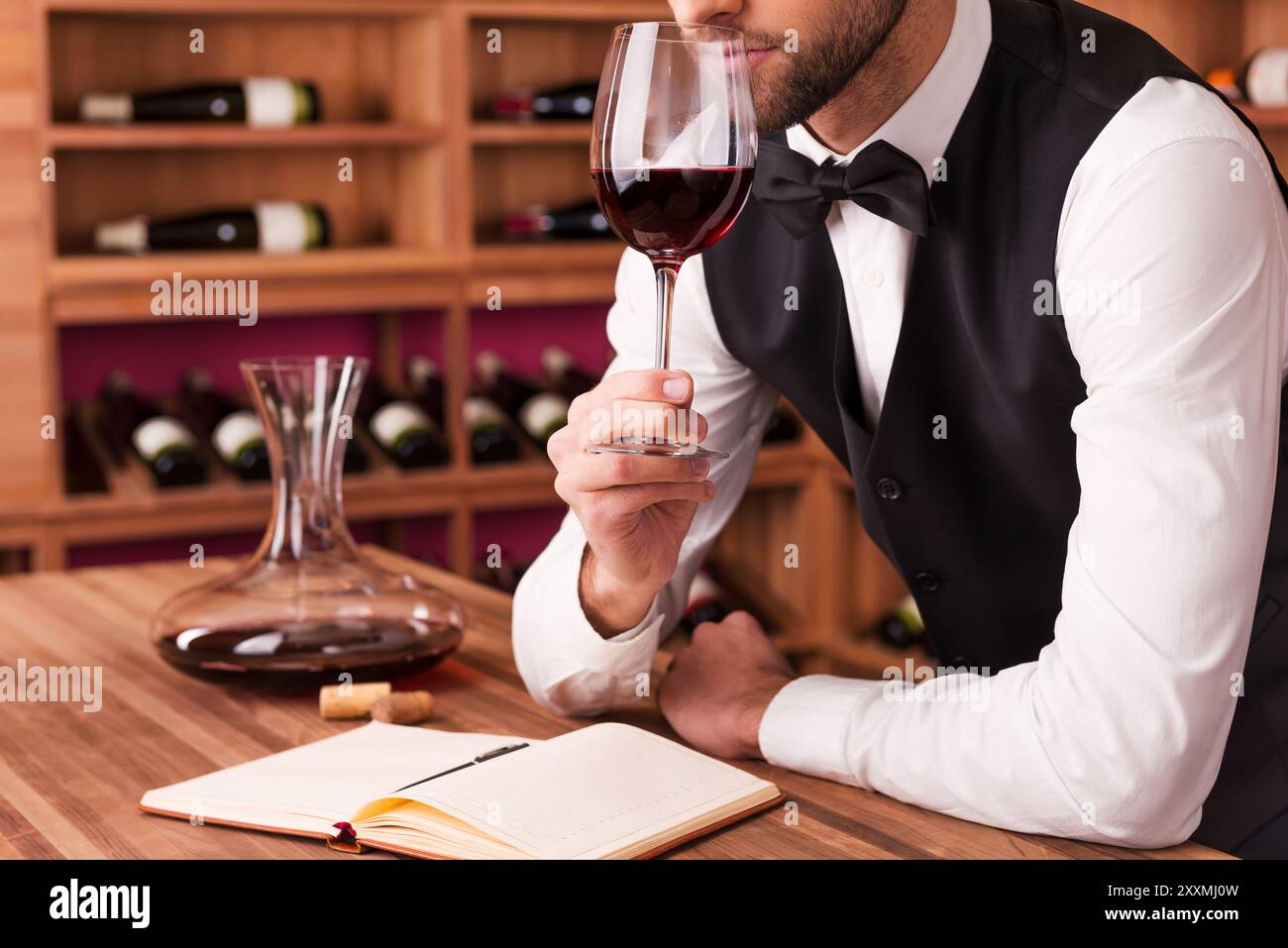 Sommelier examining wine. Cropped image of confident male sommelier ...
