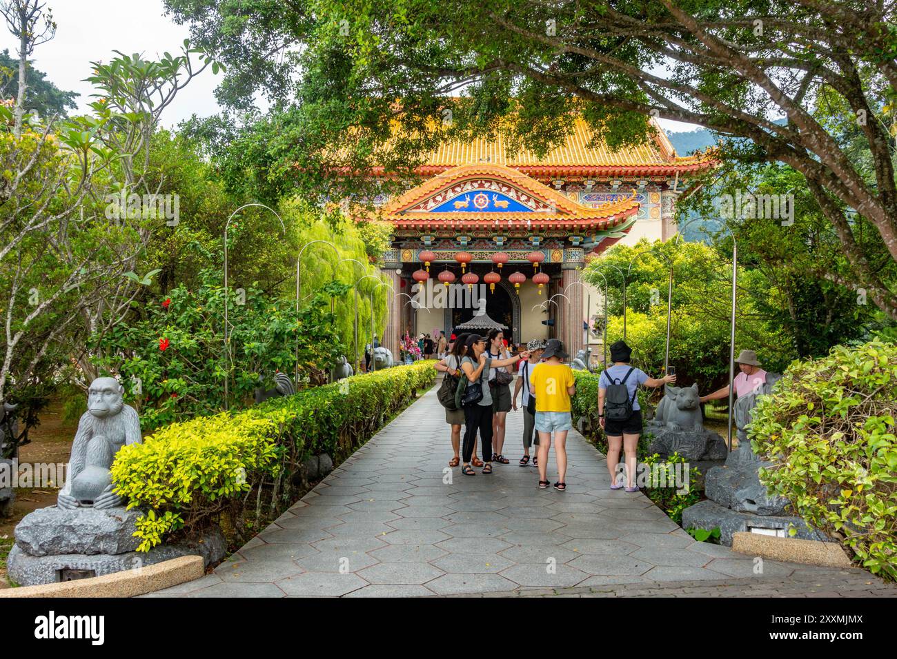 People walk along a path through a garden approaching one of the ...