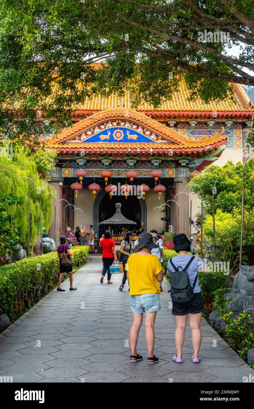 People walk along a path through a garden approaching one of the ...