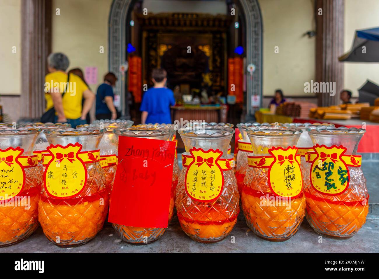Candles in jars burning, each with a prayer written on the front, in ...