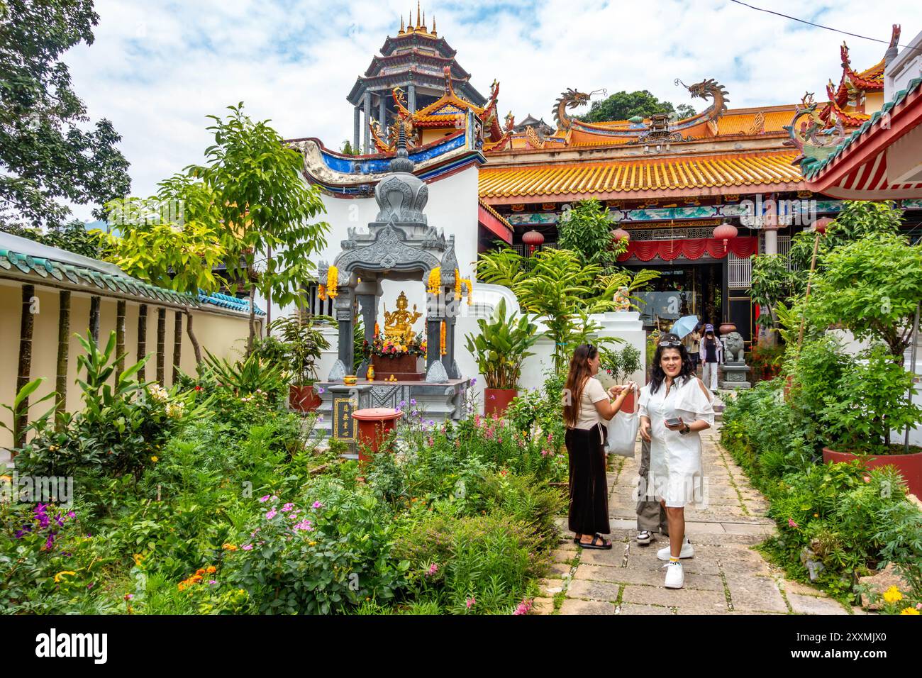 Visitors walk round the inner courtyard garden on the Amitabha Buddha ...