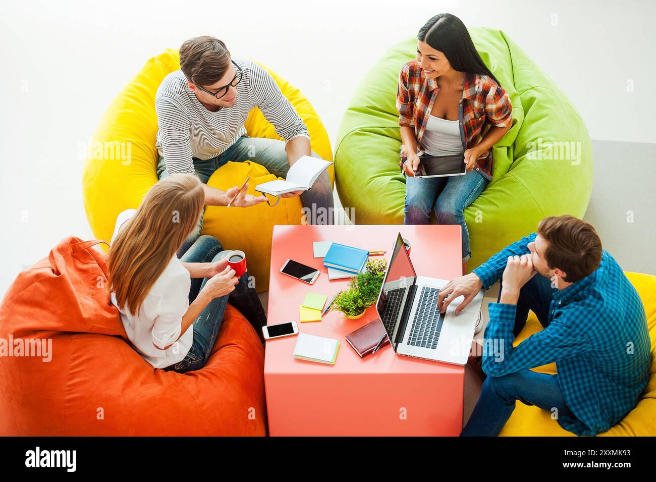 Place where ideas born. Top view of four young people working together ...