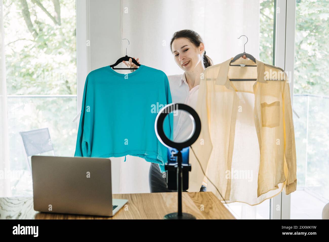 Fashion blogger showcasing outfits during live stream, content creation ...