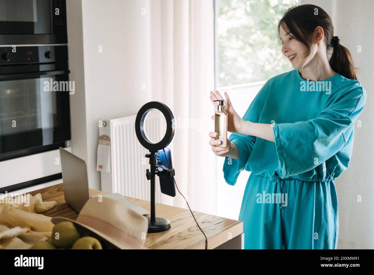 Beauty influencer demonstrating skincare product with ring light setup ...