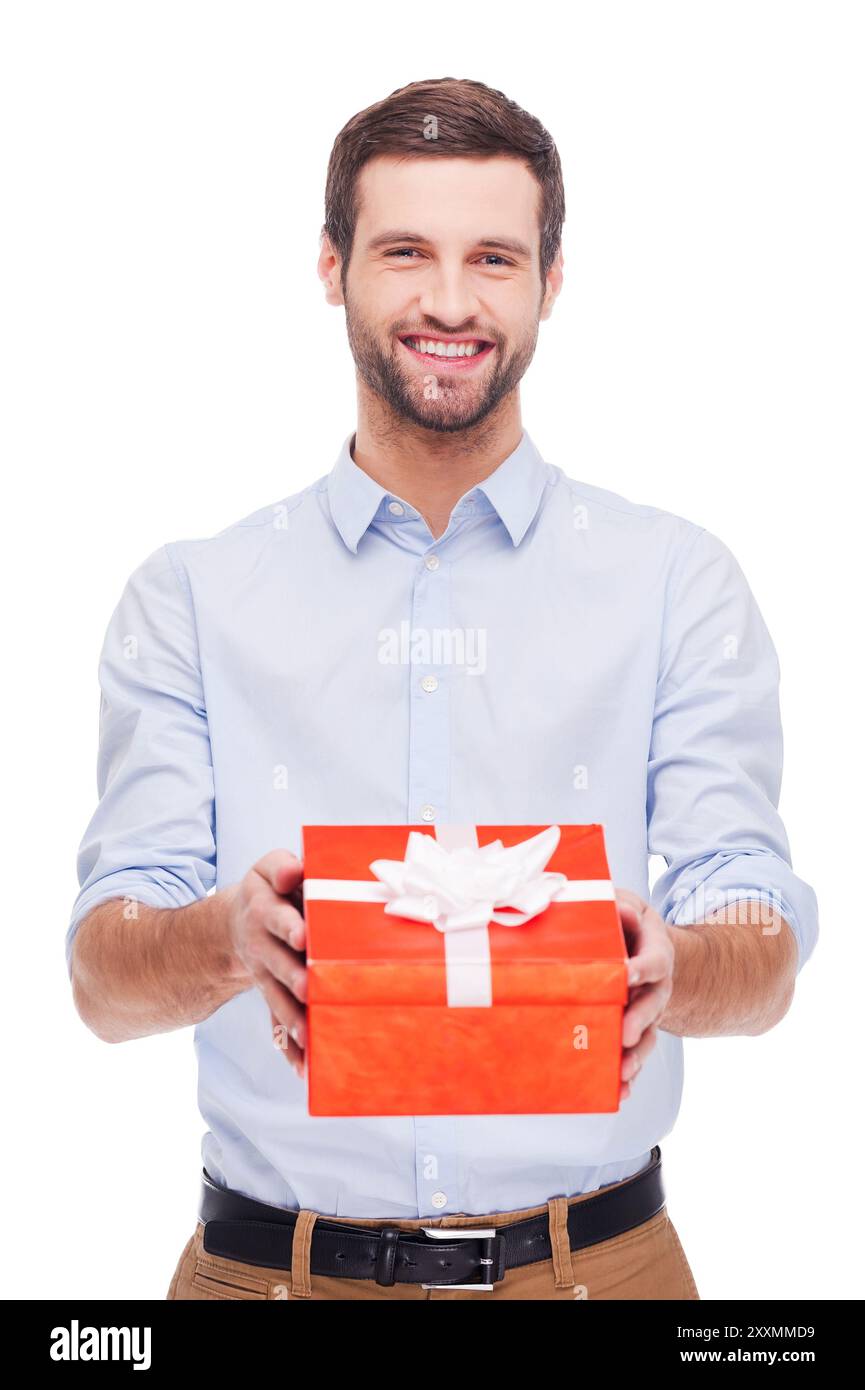 Present for you! Handsome young man stretching out a gift box and ...
