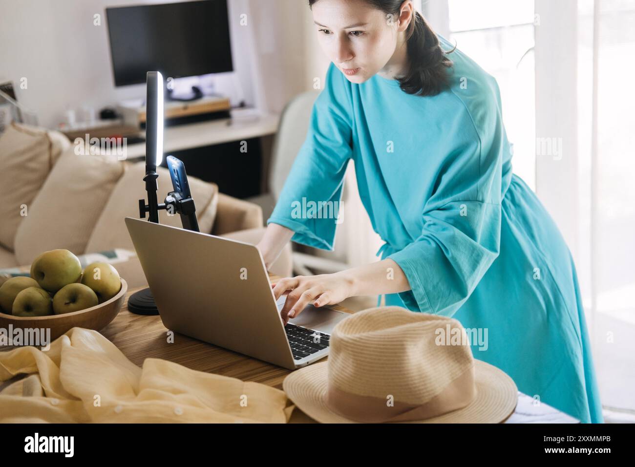 Content creator preparing to record video with ring light and laptop ...