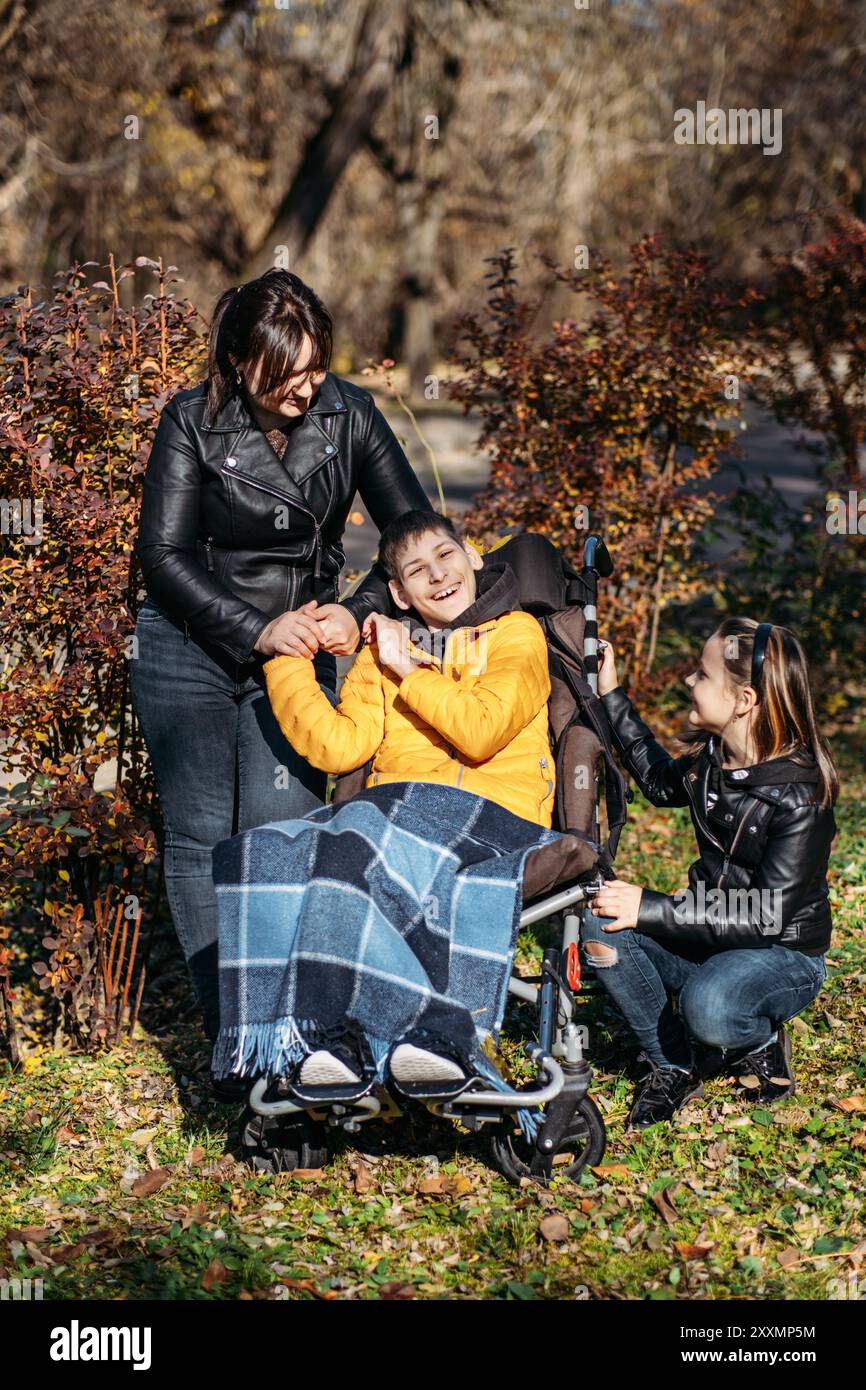 Mother and sibling providing emotional support to child in wheelchair ...