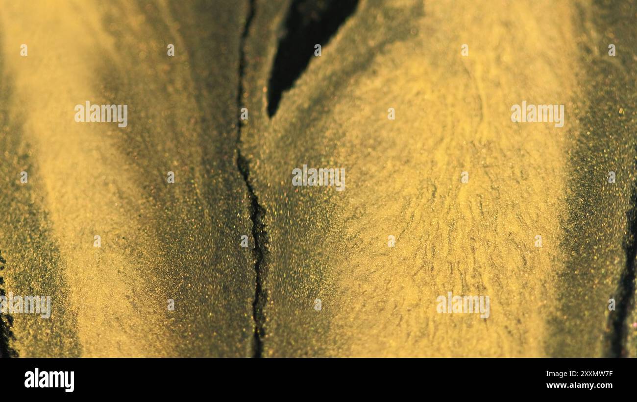 Glitter drip ink. Paint flow. Defocused yellow golden black silver ...