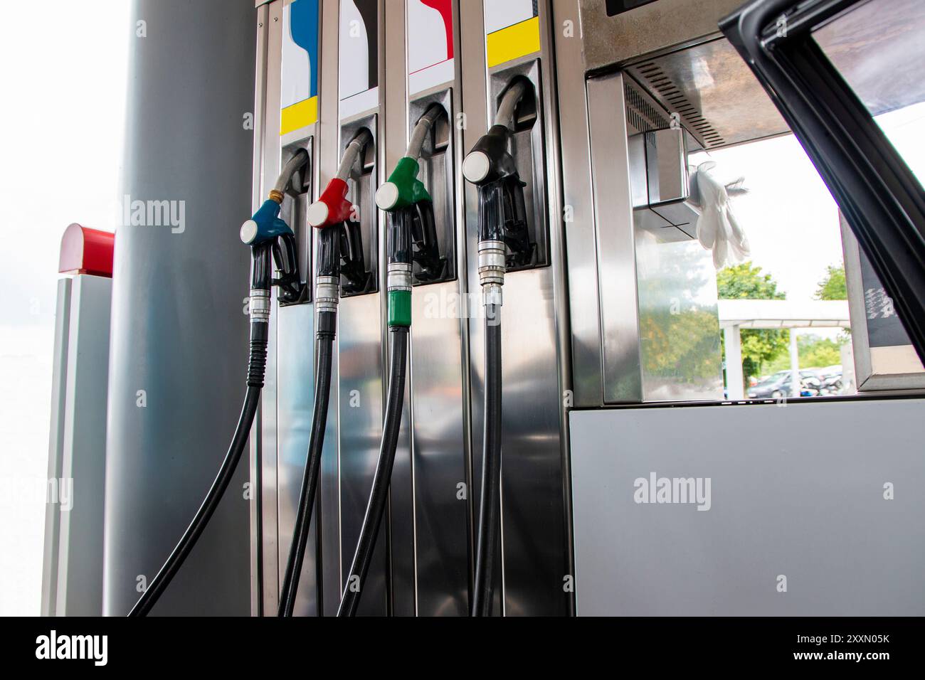 Petrol pump filling nozzles at gas station. Blue, red, green, black ...