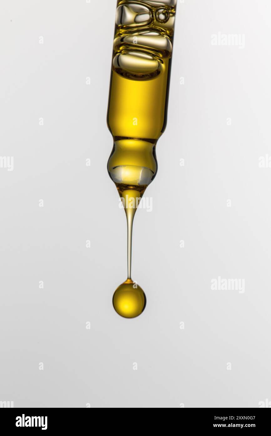 Dripping cosmetic serum from pipette on white background. Face serum ...