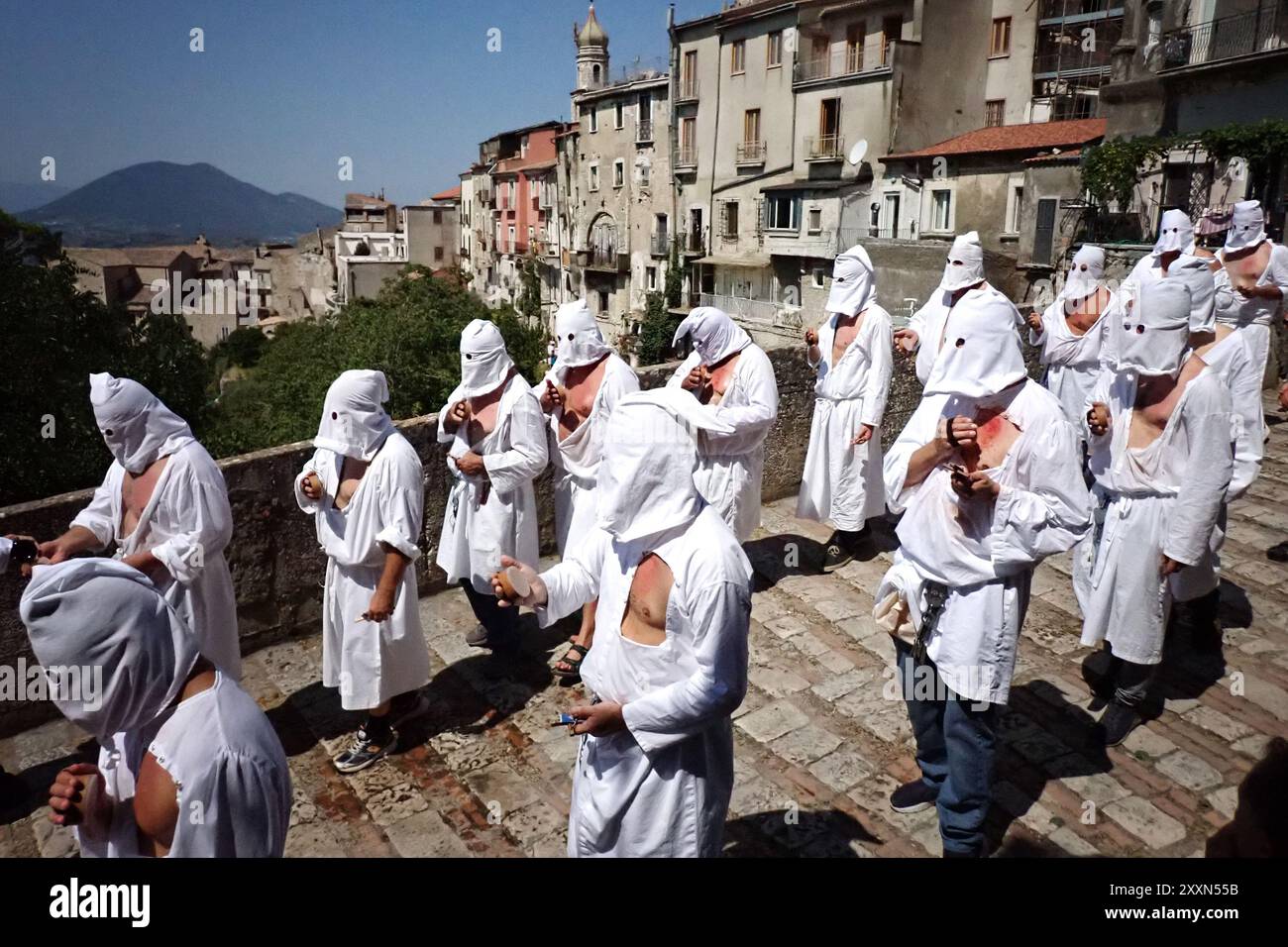 Hooded men dressed in white "Battenti" repeatedly beat their chests ...