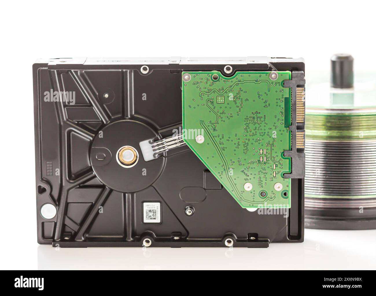 Hard disk drive (HDD) with circuit board and compact discs on white ...