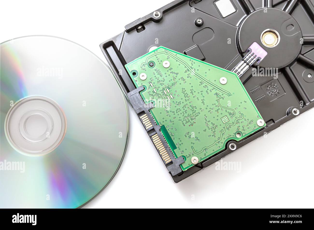 Hard disk drive (HDD) with circuit board and dvd discs on white ...