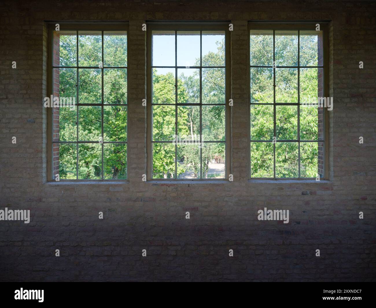 Three single-glazed windows in an exposed brick wall at an old ...