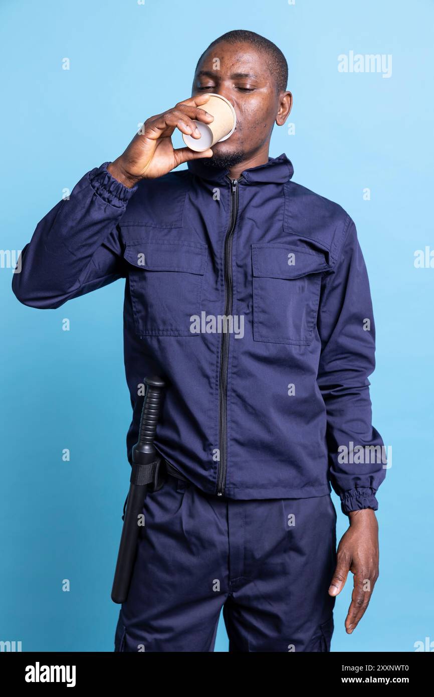 African american agent drinking coffee cup against blue background ...