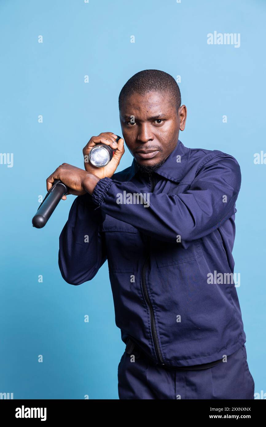 Trained bodyguard inspecting the perimeter with flashlight and weapon ...