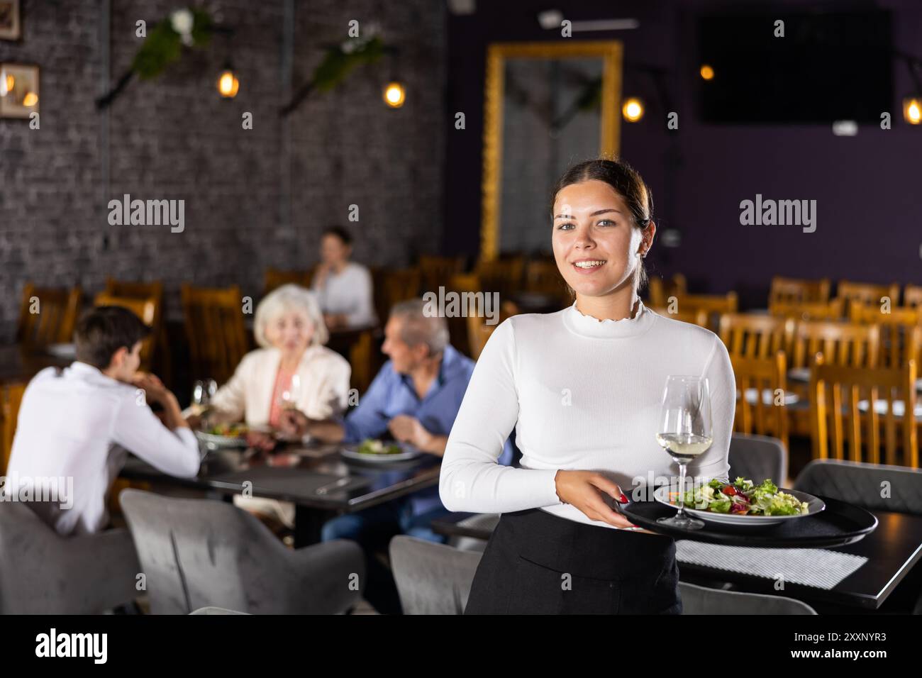 Smiling female owner of restaurant standing with serving tray Stock ...