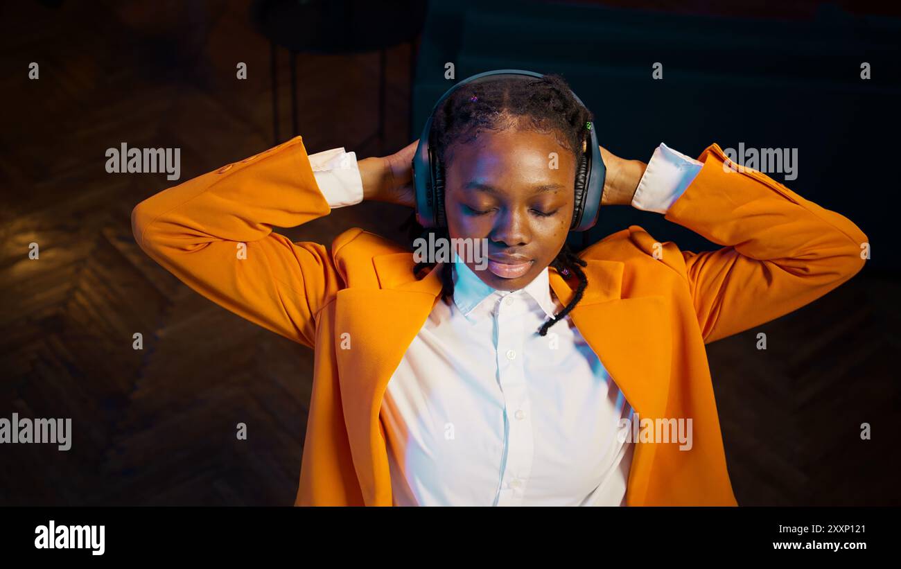 Young pupil relaxing with modern music on headphones, sitting laid back ...