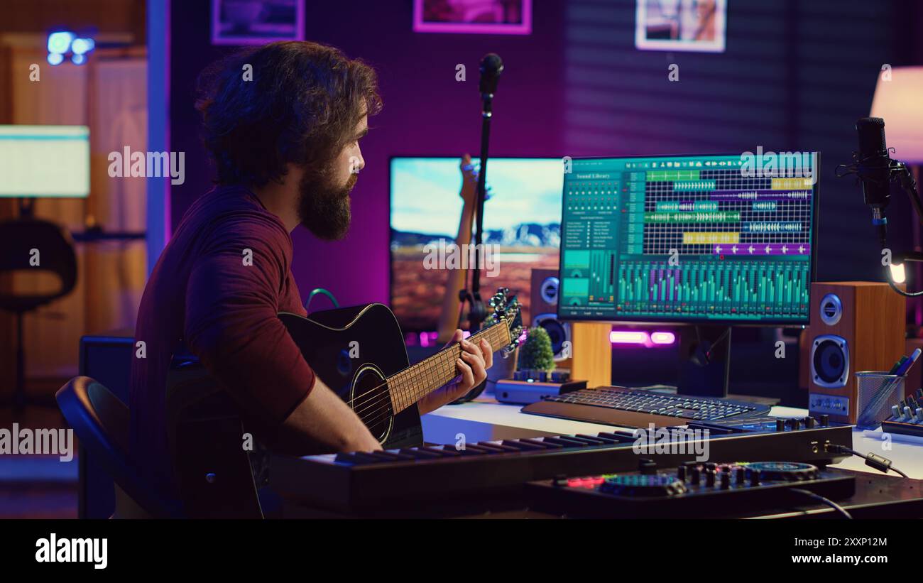 Music producer mixing guitar sounds played by him on acoustic ...