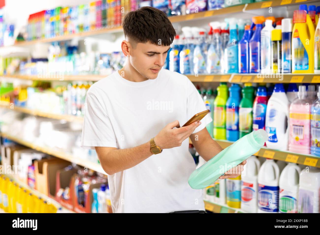 in supermarket, man scans qr code of detergent, typed on label Stock ...