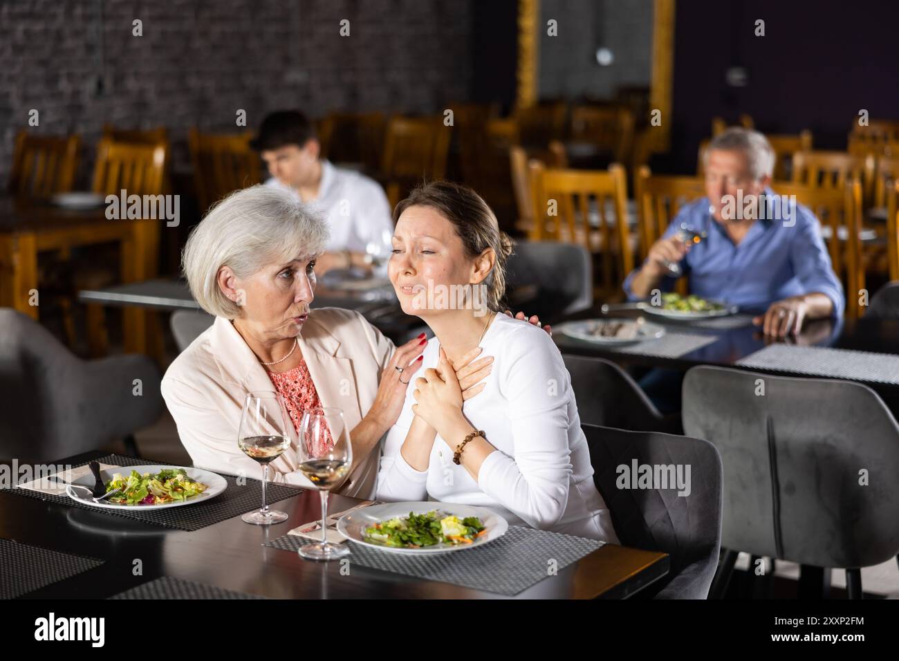 Elderly woman and adult woman having dinner in restaurant Stock Photo ...