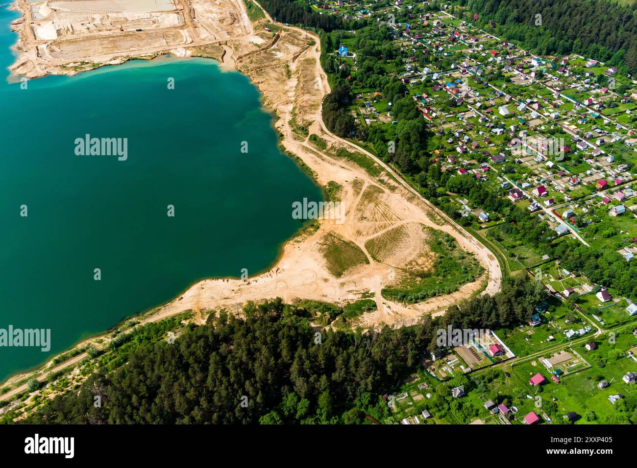 Aerial view of a settlement next to a lake formed on the site of a sand ...