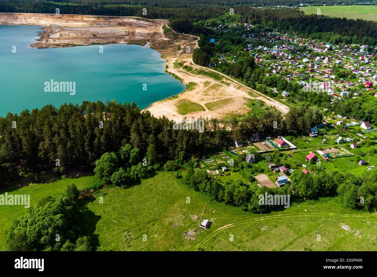 Aerial view of a settlement next to a lake formed on the site of a sand ...