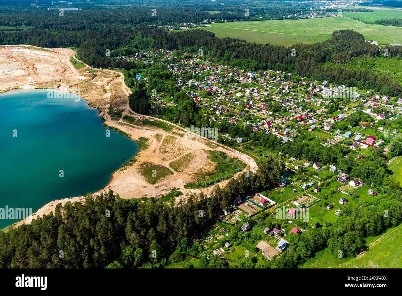 Aerial view of a settlement next to a lake formed on the site of a sand ...