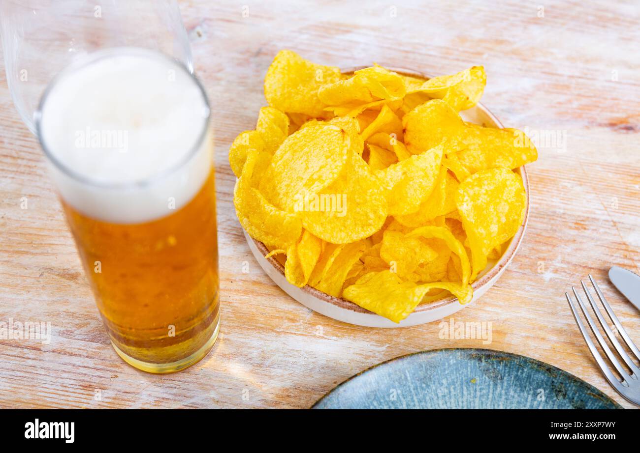 Crispy potato chips with glass of cold beer Stock Photo - Alamy