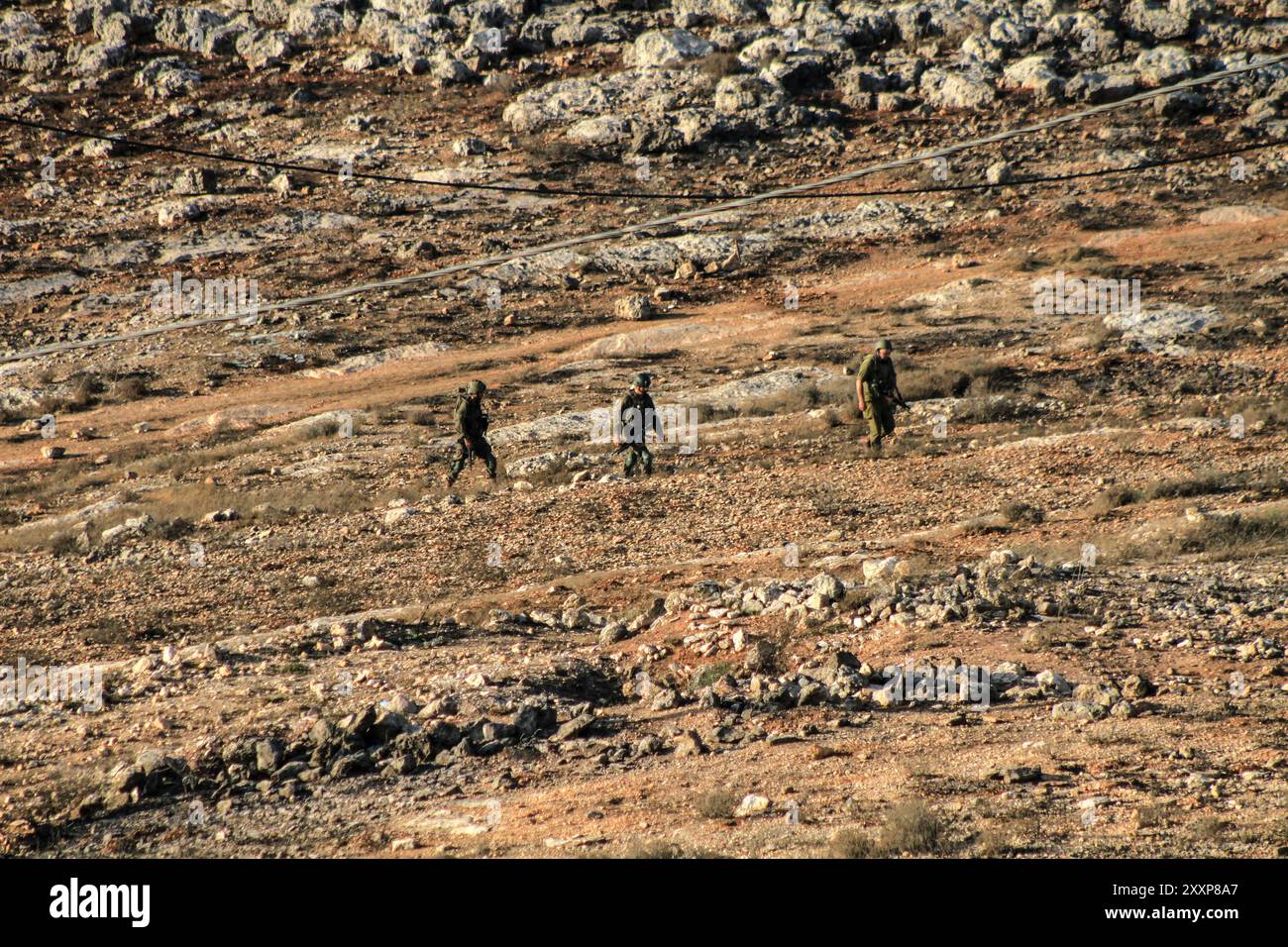 An Israeli military force guards Jewish settlers from the settlement of ...