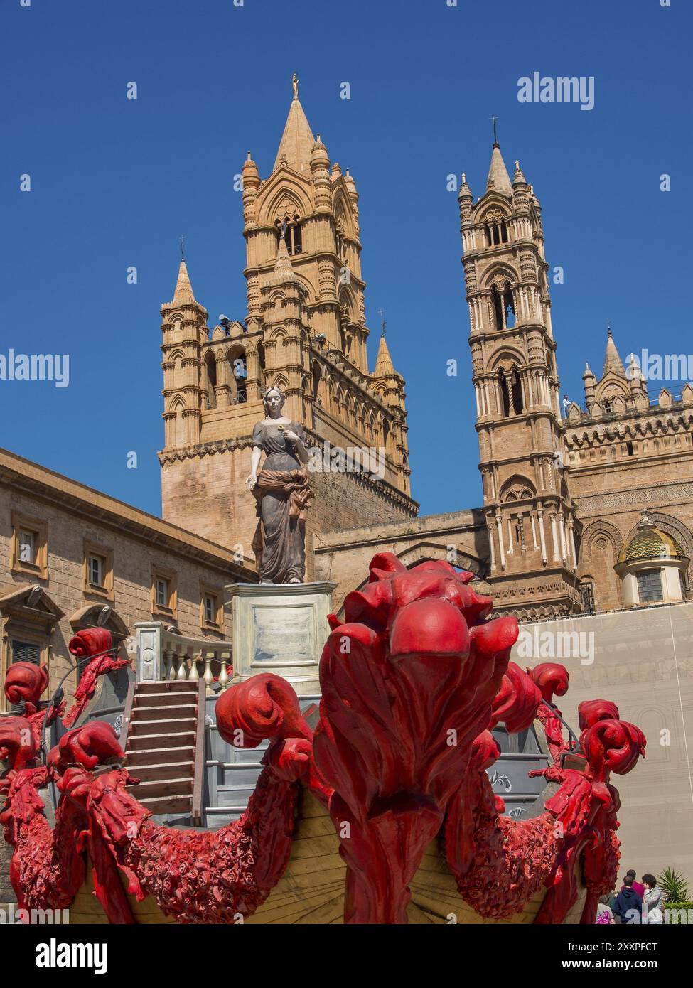 Historic building with gothic towers and a prominent statue in front of ...