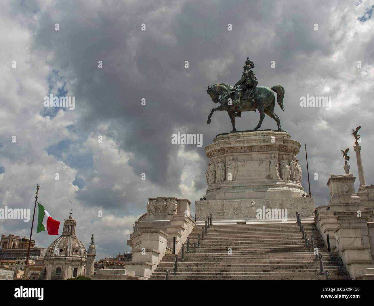 An imposing equestrian statue on a pedestal, flanked by an Italian flag ...