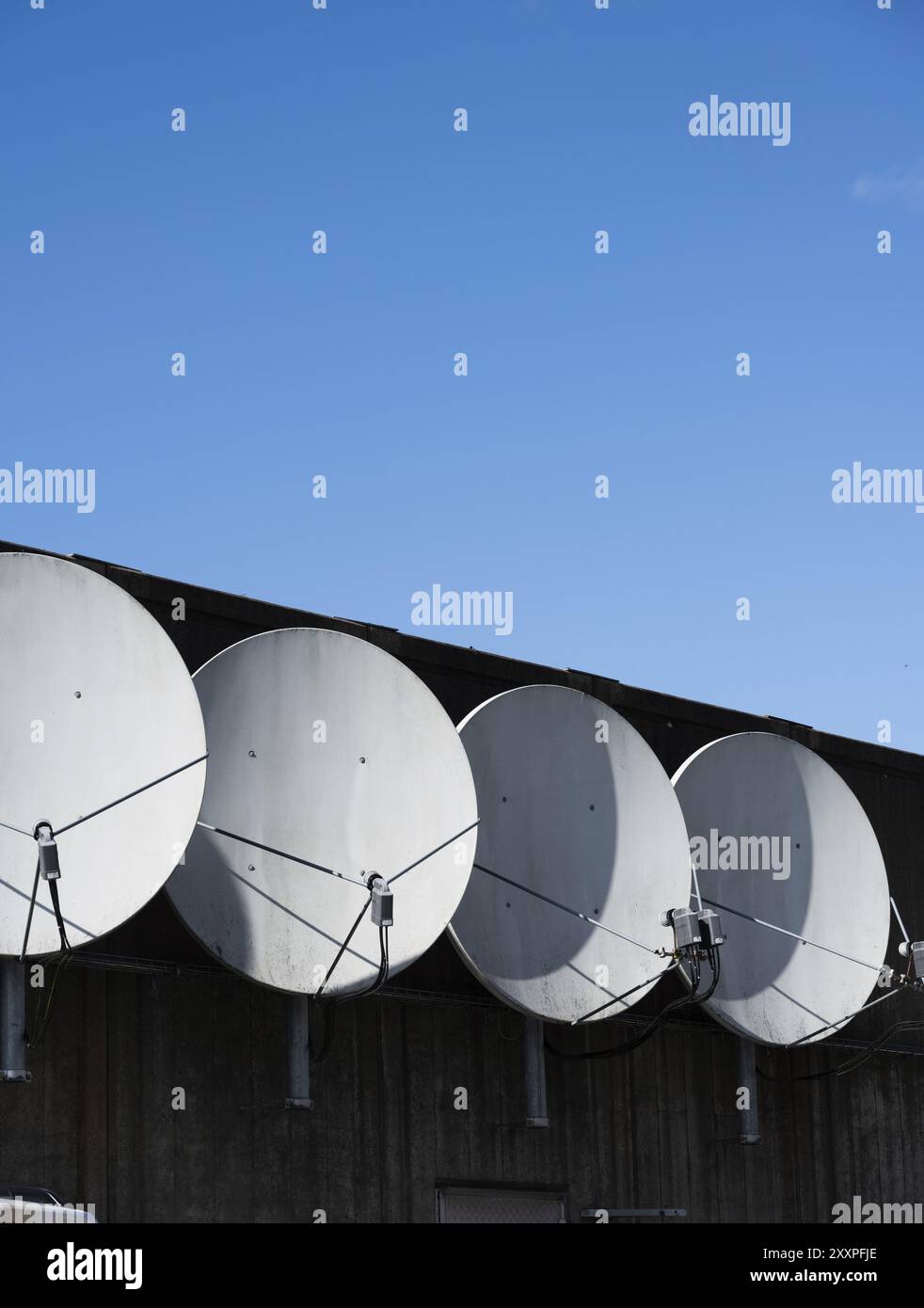 Four parabolic antennae on the facade of a building Stock Photo - Alamy