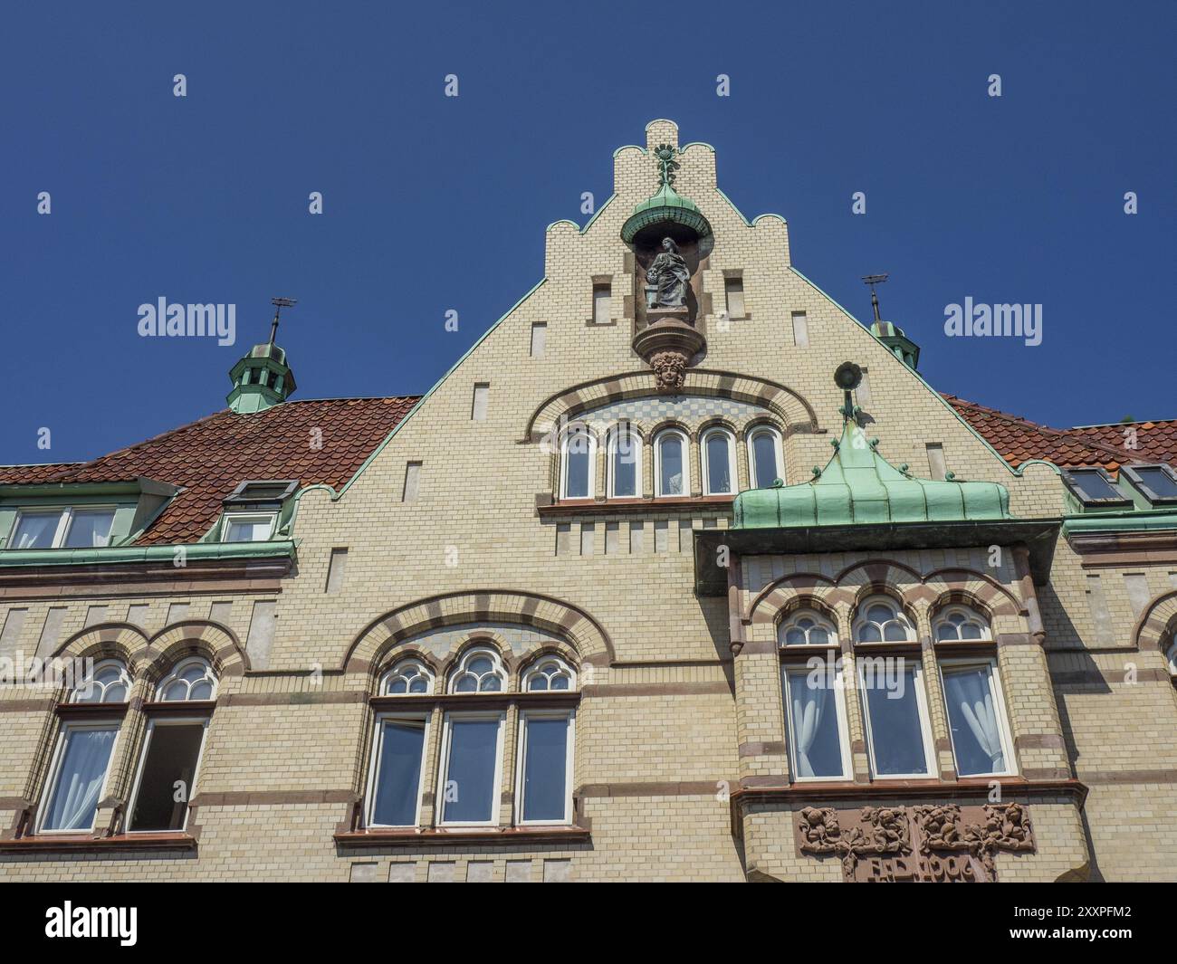 Building with historic charm, green towers and detailed facade under a ...