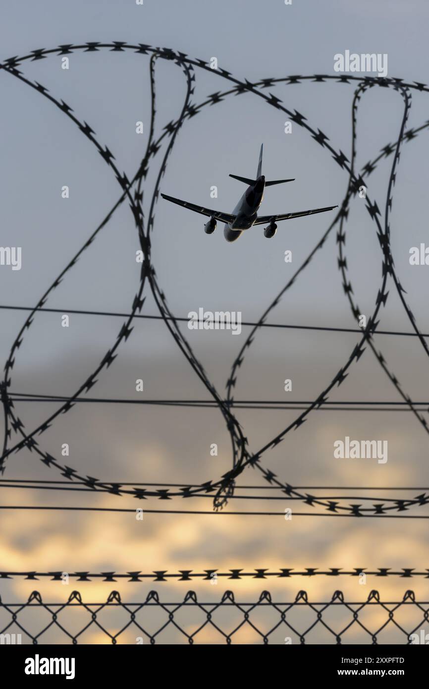 Symbolic image security, passenger aircraft taking off, security fence ...