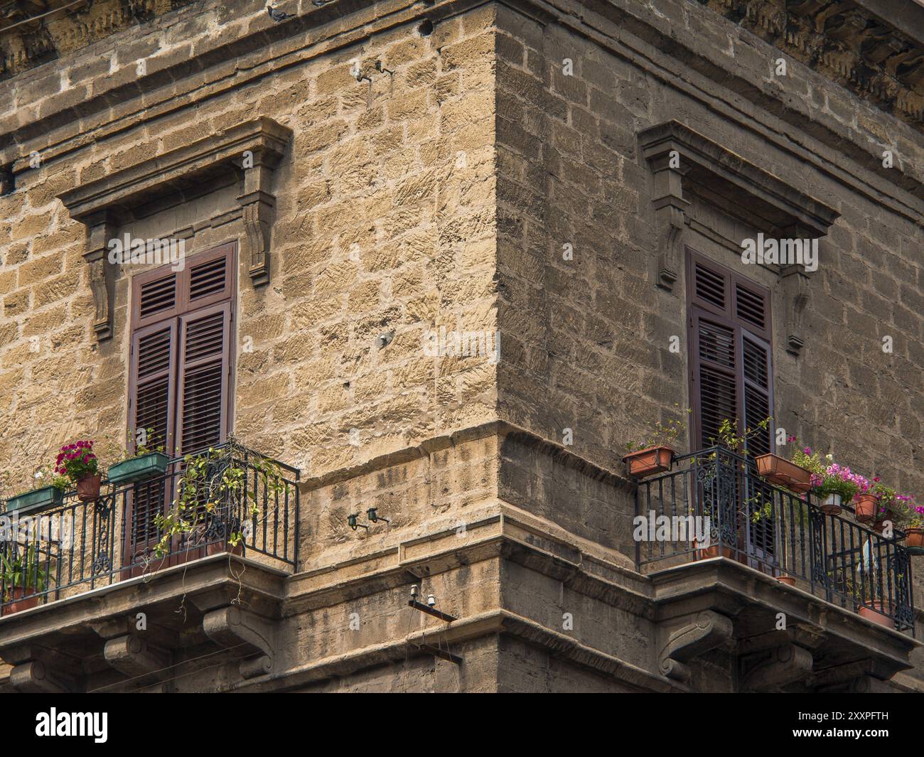 Corner building with balconies, shutters and plants, emphasising the historical architecture ...