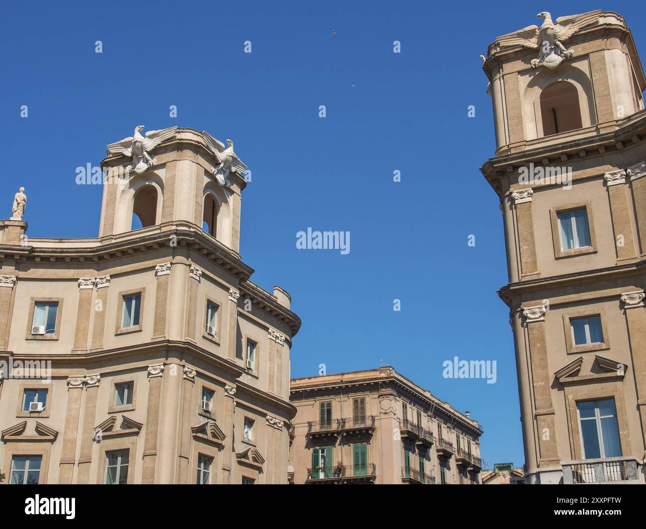 Two historic-looking towers rise into the clear blue sky, palermo ...