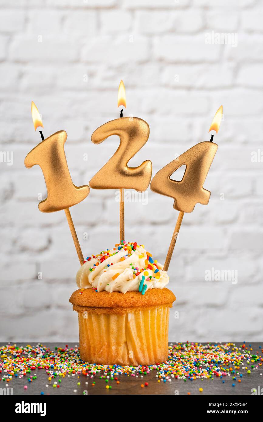 Cupcake with number 124 birthday candle - White block wall background ...