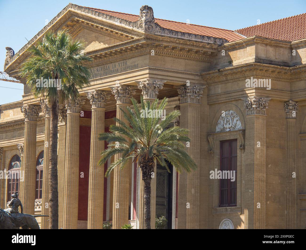 Historic building with ancient columns and palm trees in the foreground ...