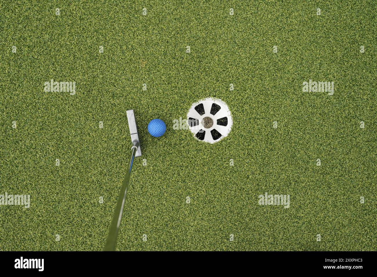 Miniature golf putter by blue ball and hole Stock Photo - Alamy