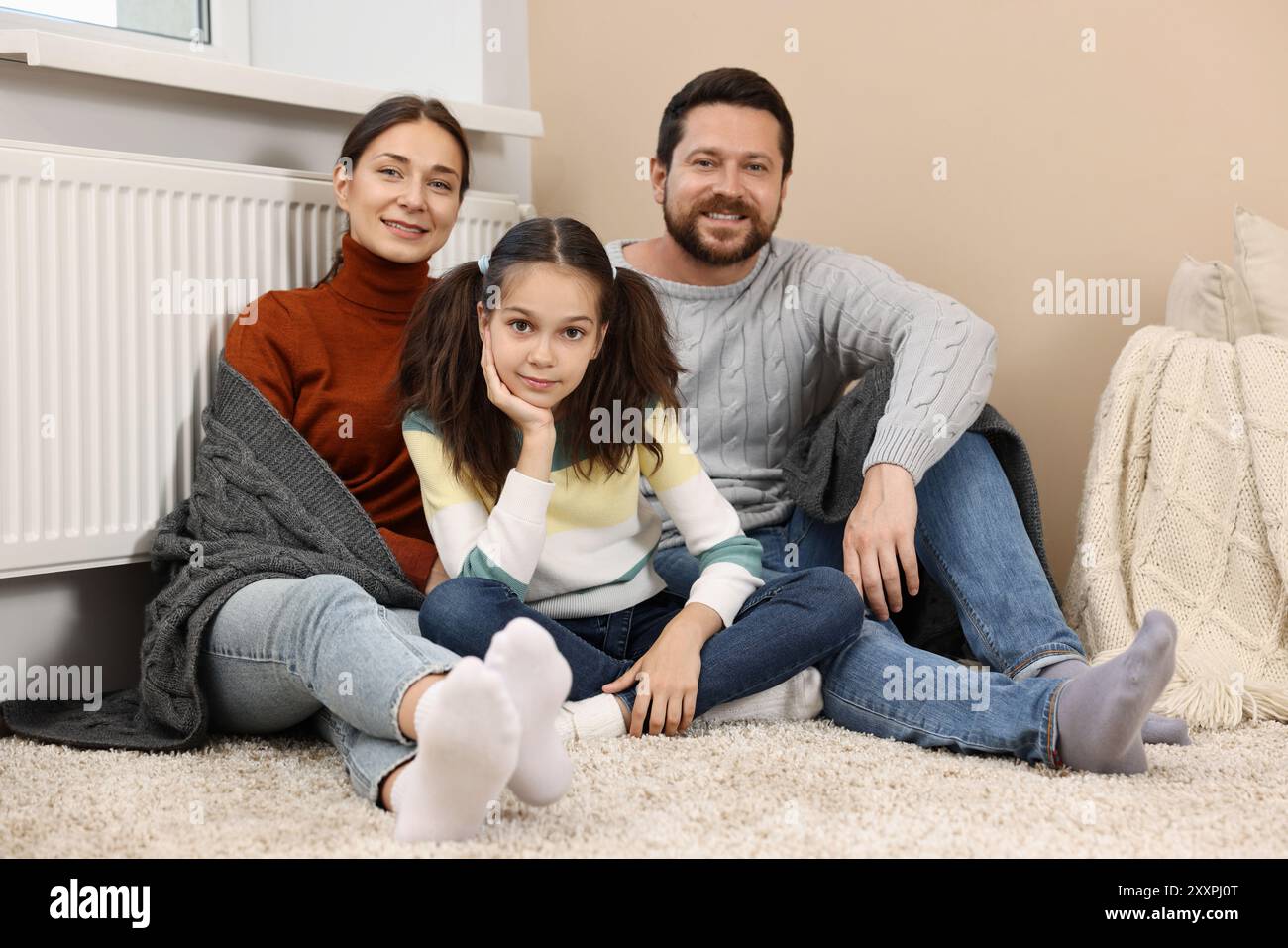 Happy family near heating radiator at home Stock Photo - Alamy