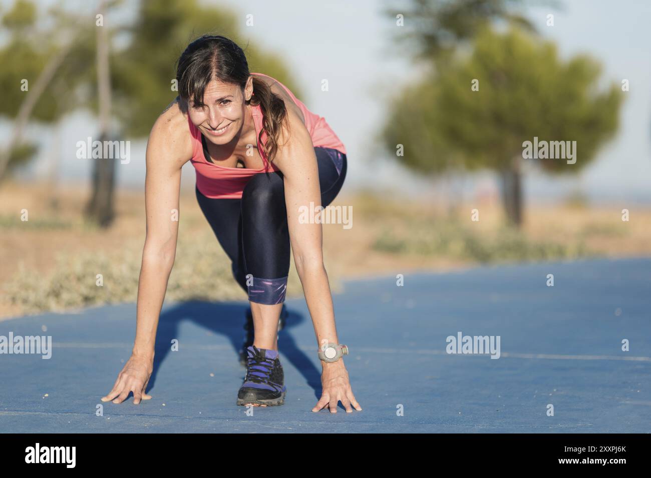 Athletic woman on running track getting ready to start run Stock Photo ...