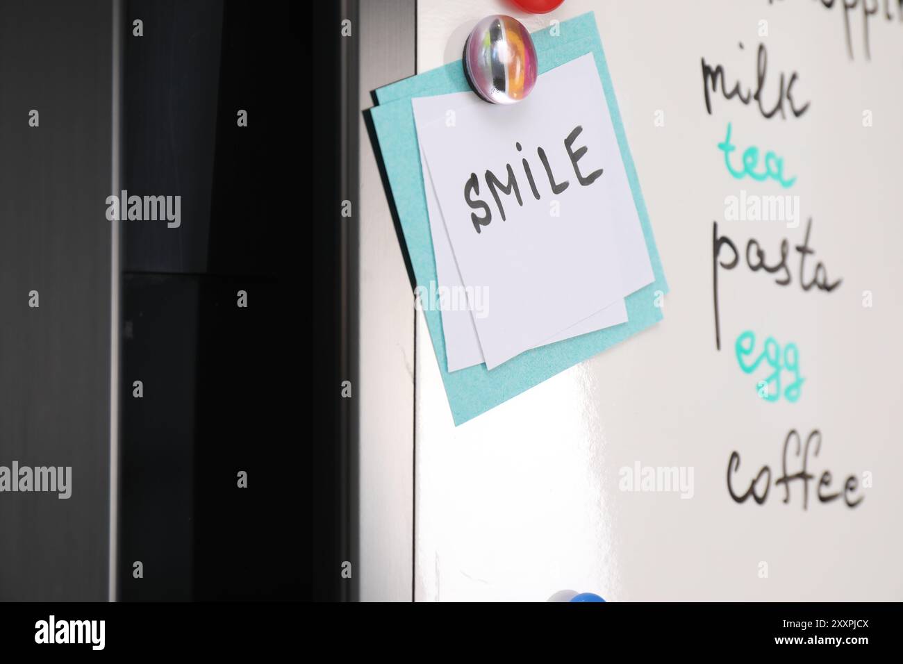 Magnetic board with shopping list and notes on refrigerator, closeup ...