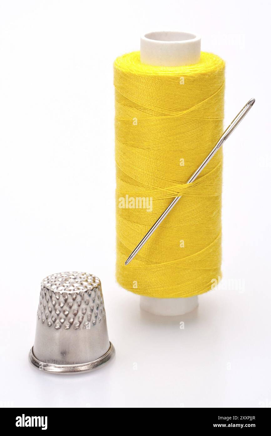 Spool of thread for sewing with needle and thimble Stock Photo - Alamy