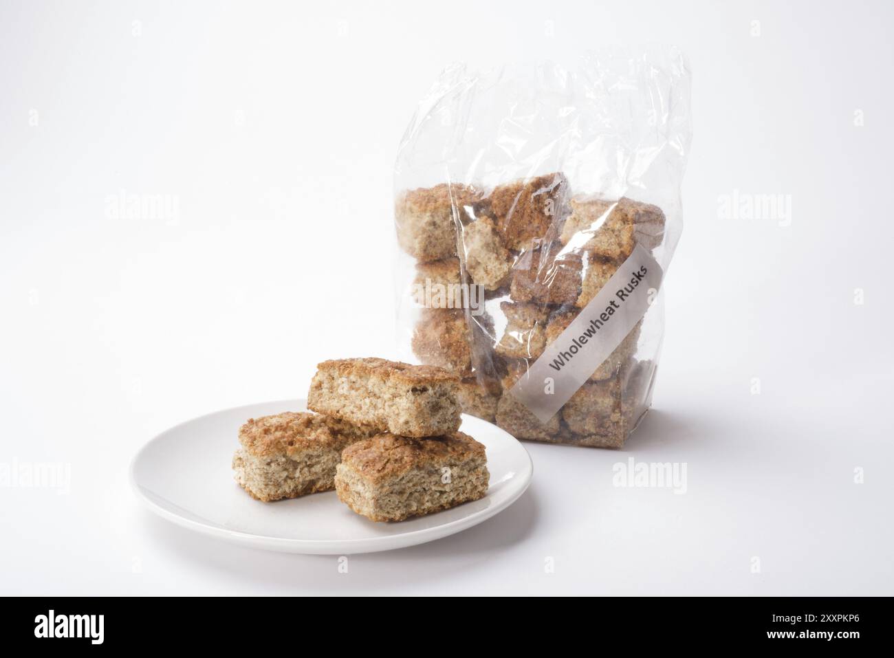 Wholewheat rusks stacked in a plastic bag as well as some on a plate on ...